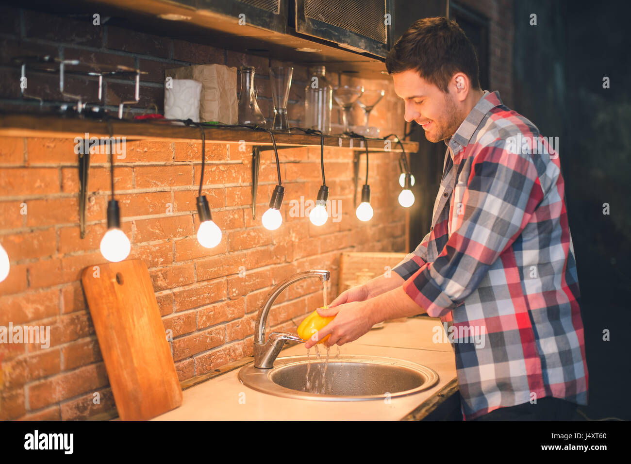Young man vegan wash bell paper dinner preparation Stock Photo - Alamy