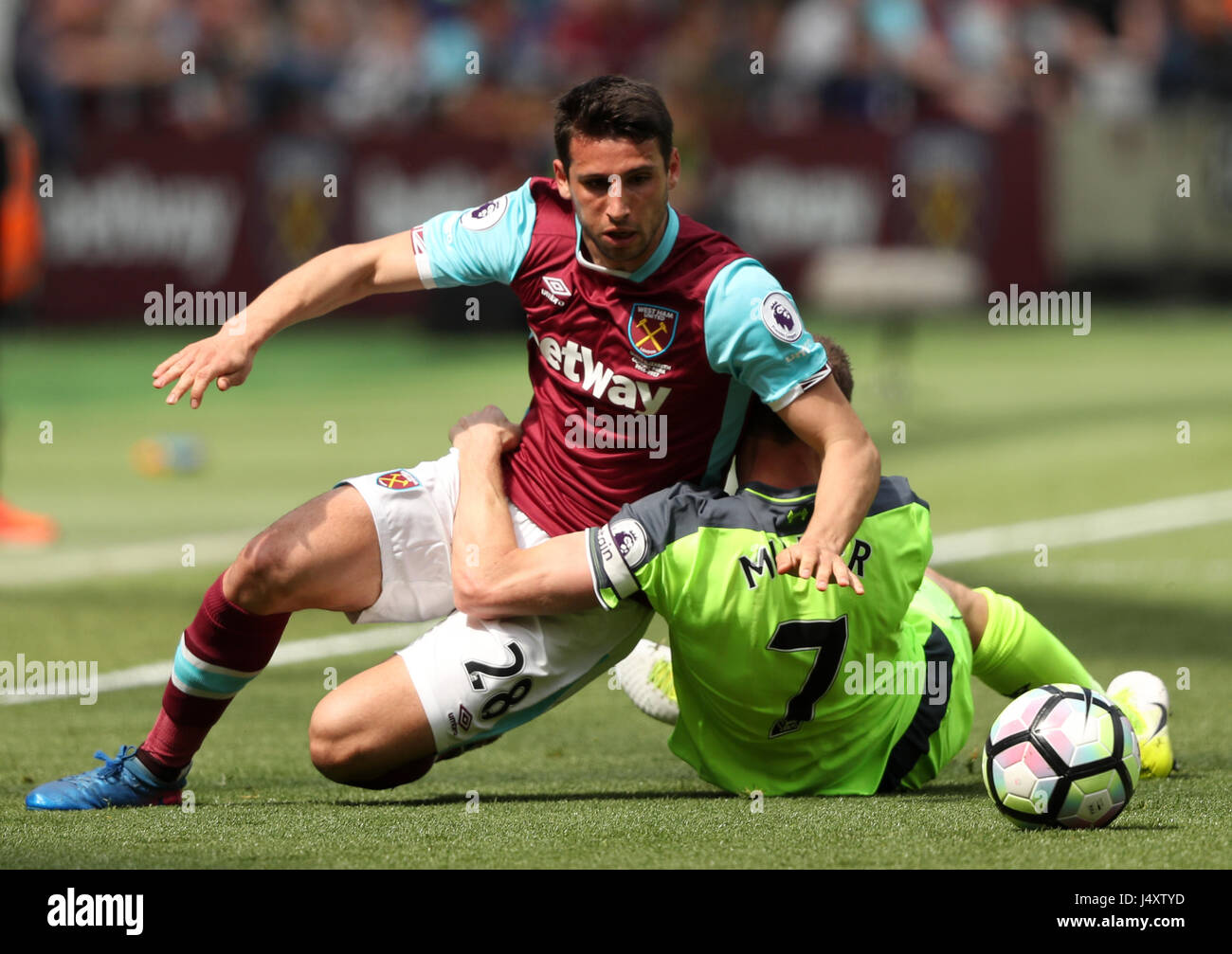 West Ham United's Jonathan Calleri (left) trips over Liverpool's James ...