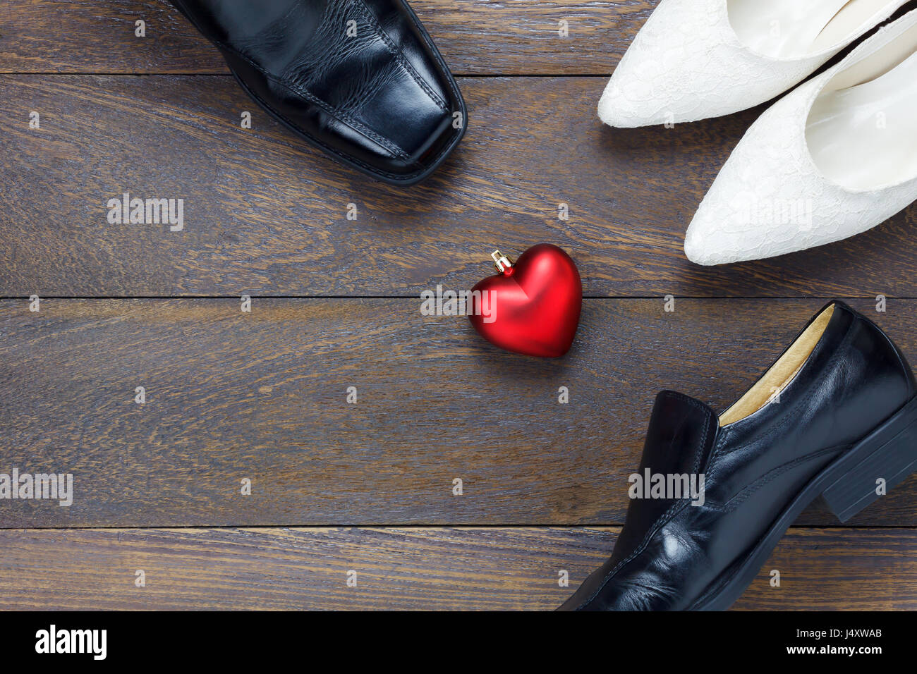 Top view heart shape with men's shoes and women's shoes on wooden ...