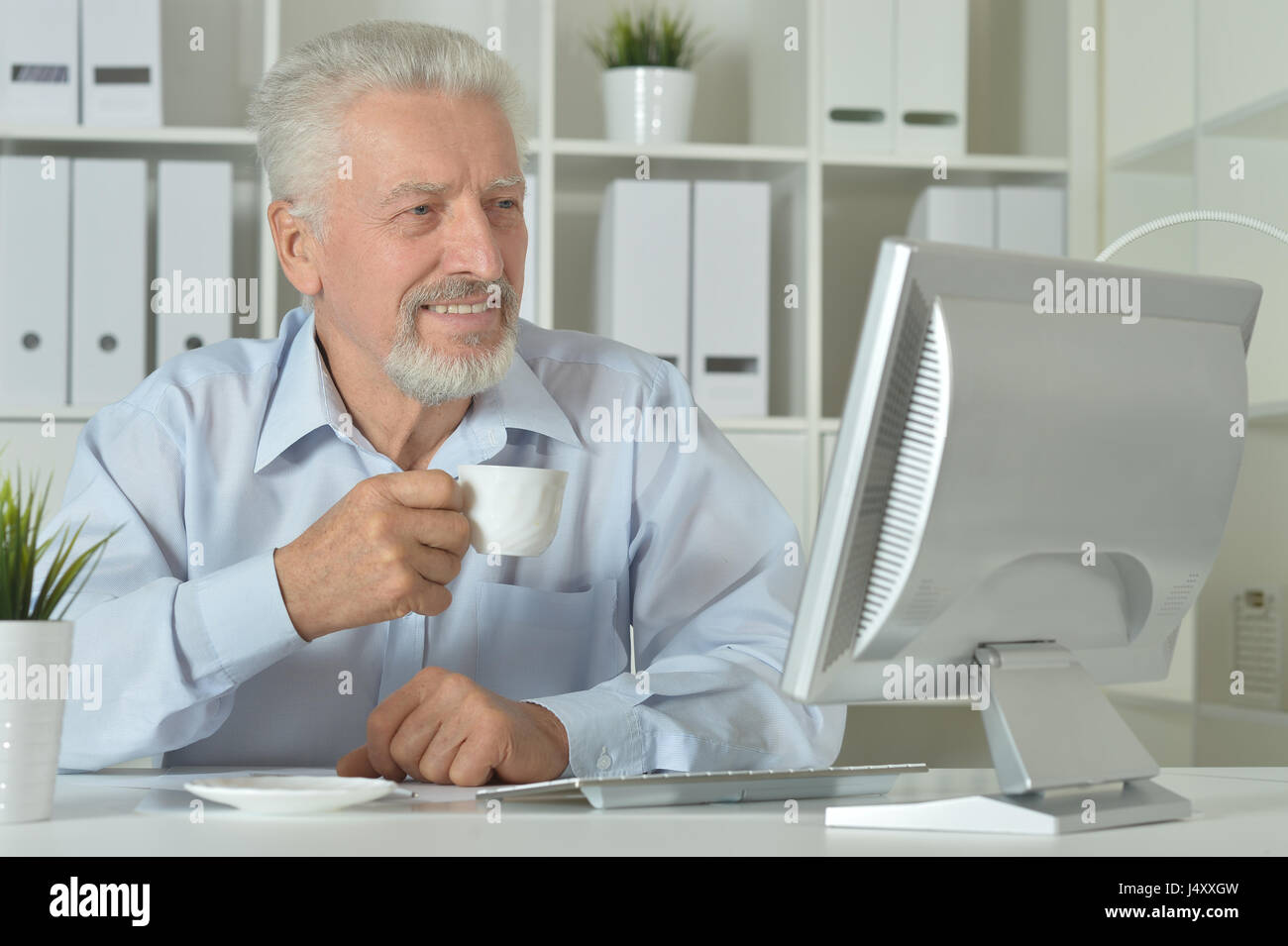 Old businessman with a laptop working Stock Photo - Alamy