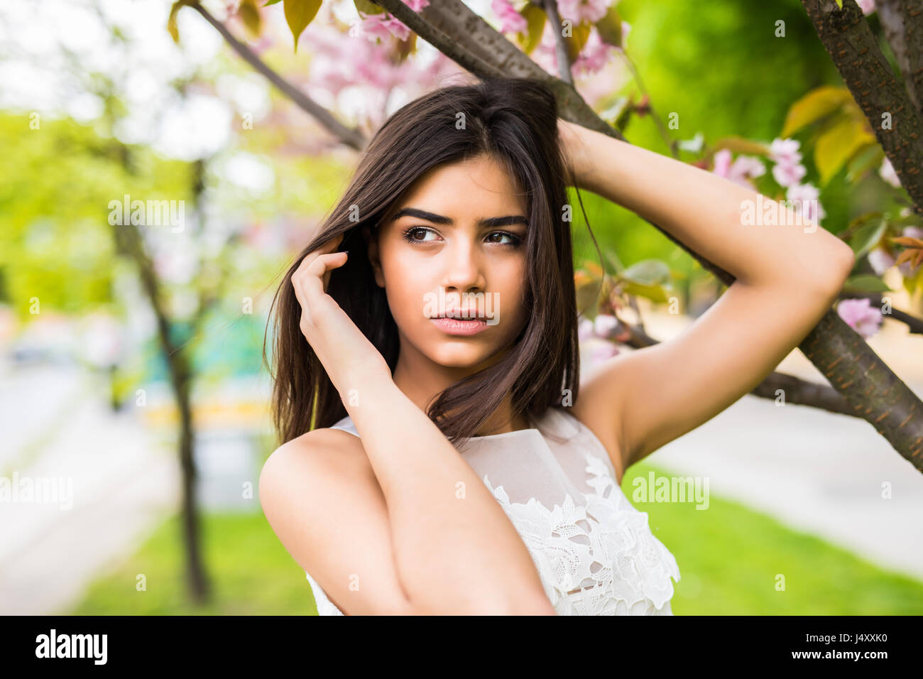 Girl with sakura tree flowers. Focus on face Stock Photo - Alamy