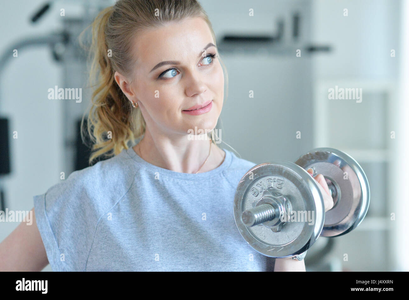 Young woman in a gym with a dumbbell Stock Photo - Alamy