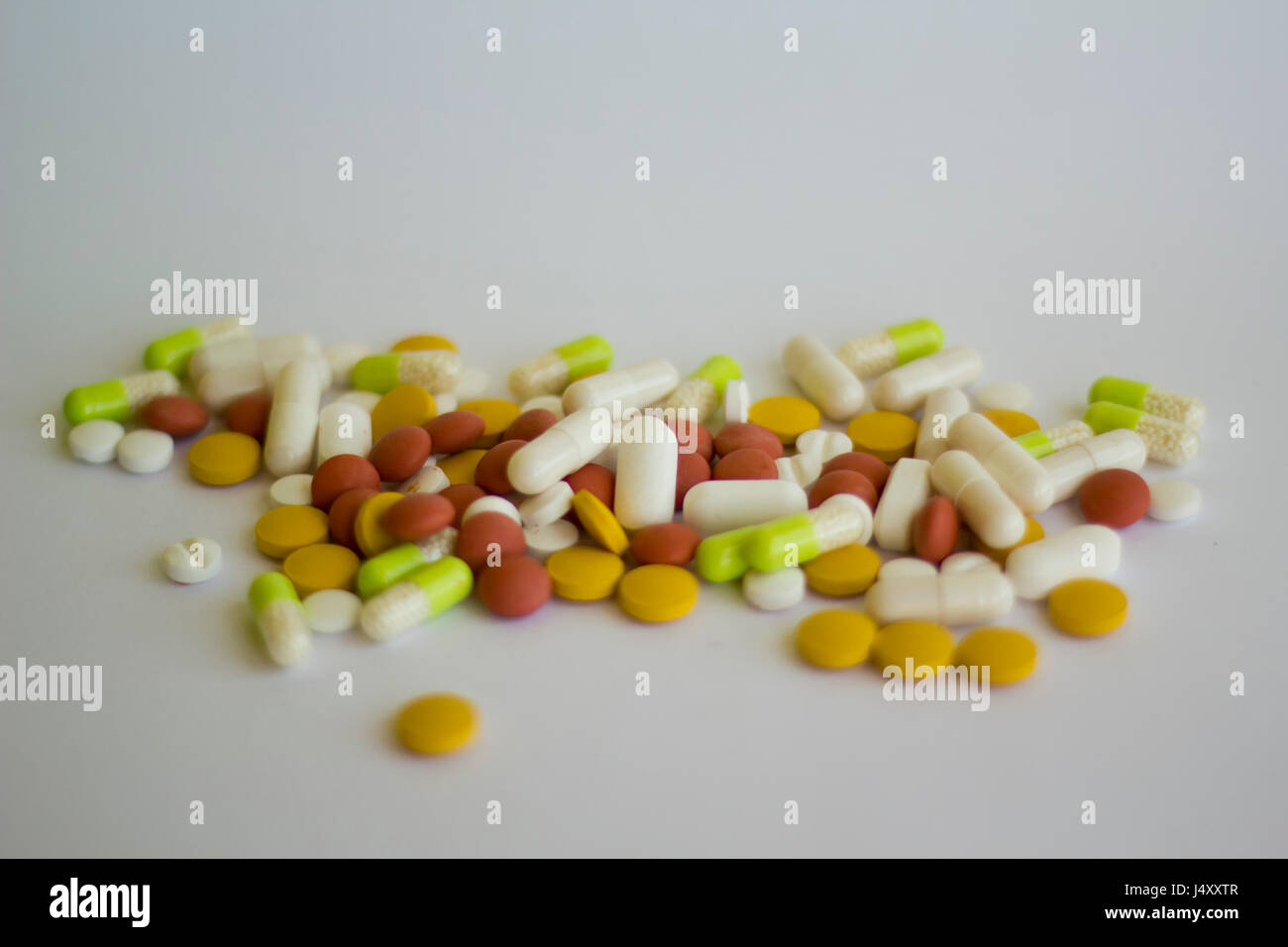 Different color pills on a white background Stock Photo - Alamy