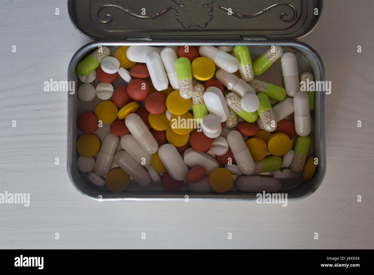 Assorted pills in a metal box on a white background Stock Photo - Alamy