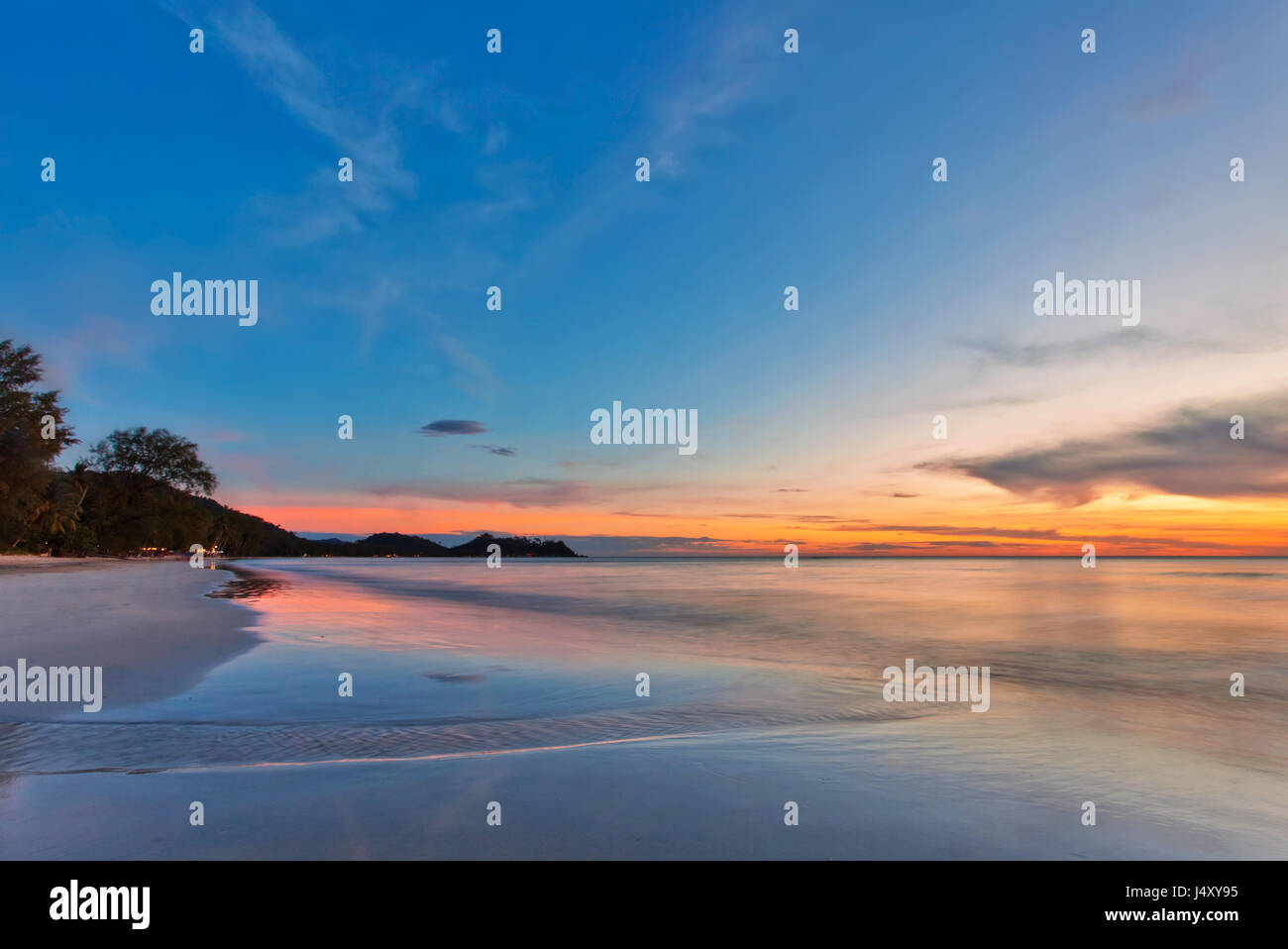 Tropical beach in ebb time on sunset background Stock Photo - Alamy