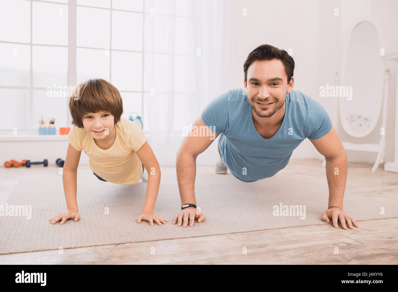 Father and son exercise together at home Stock Photo - Alamy