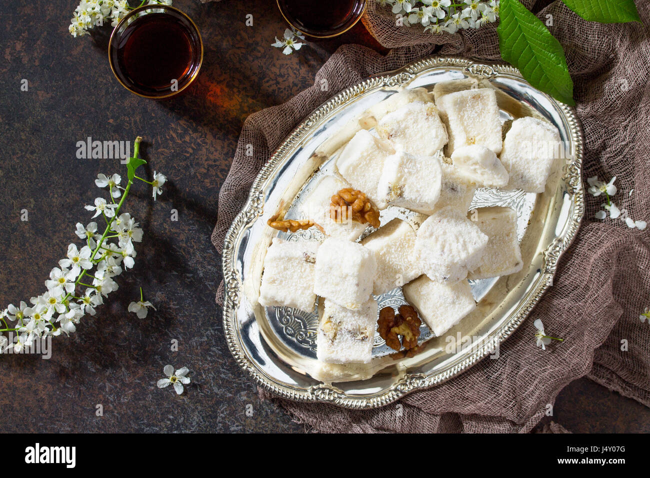 Rahat Lokum with walnuts on the kitchen table. Turkish and Arabic ...