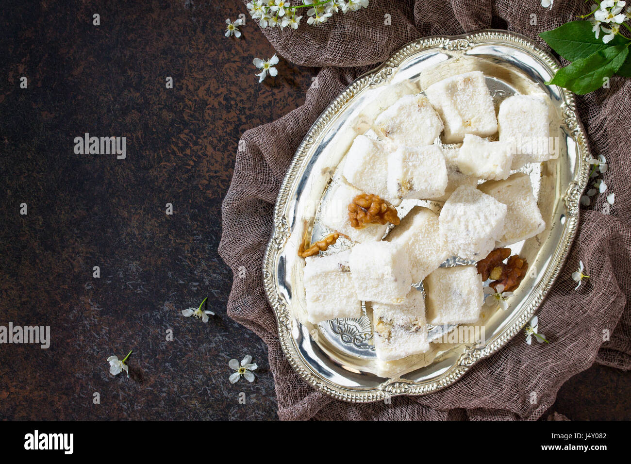 Rahat Lokum with walnuts on the kitchen table. Turkish and Arabic ...