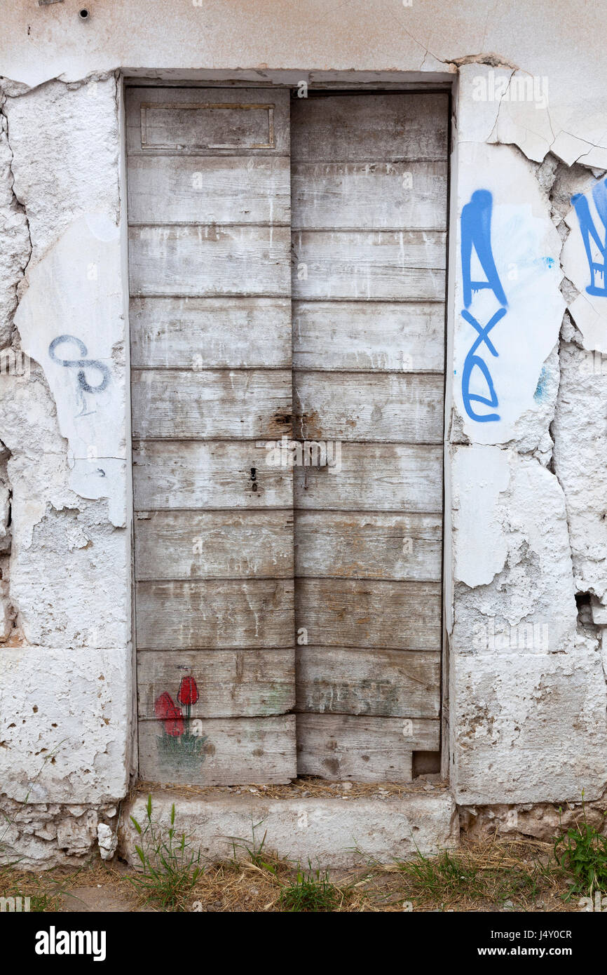 very old wooden doors with padlock in derelict building with cracked ...