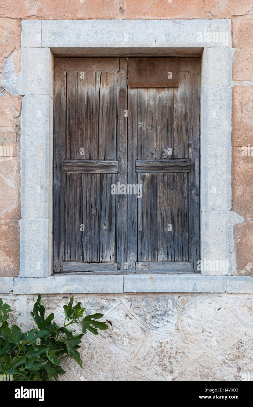 very old shutters in front of window in ancient greek building with fig ...