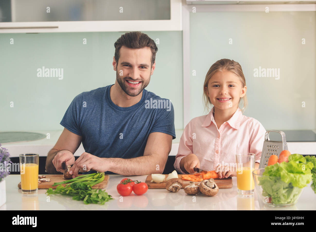 Young father and daughter cooking meal together Stock Photo - Alamy