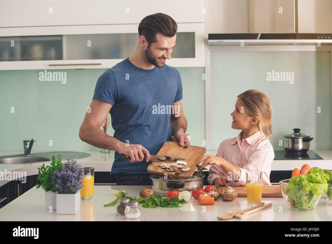 Young father and daughter cooking meal together Stock Photo - Alamy