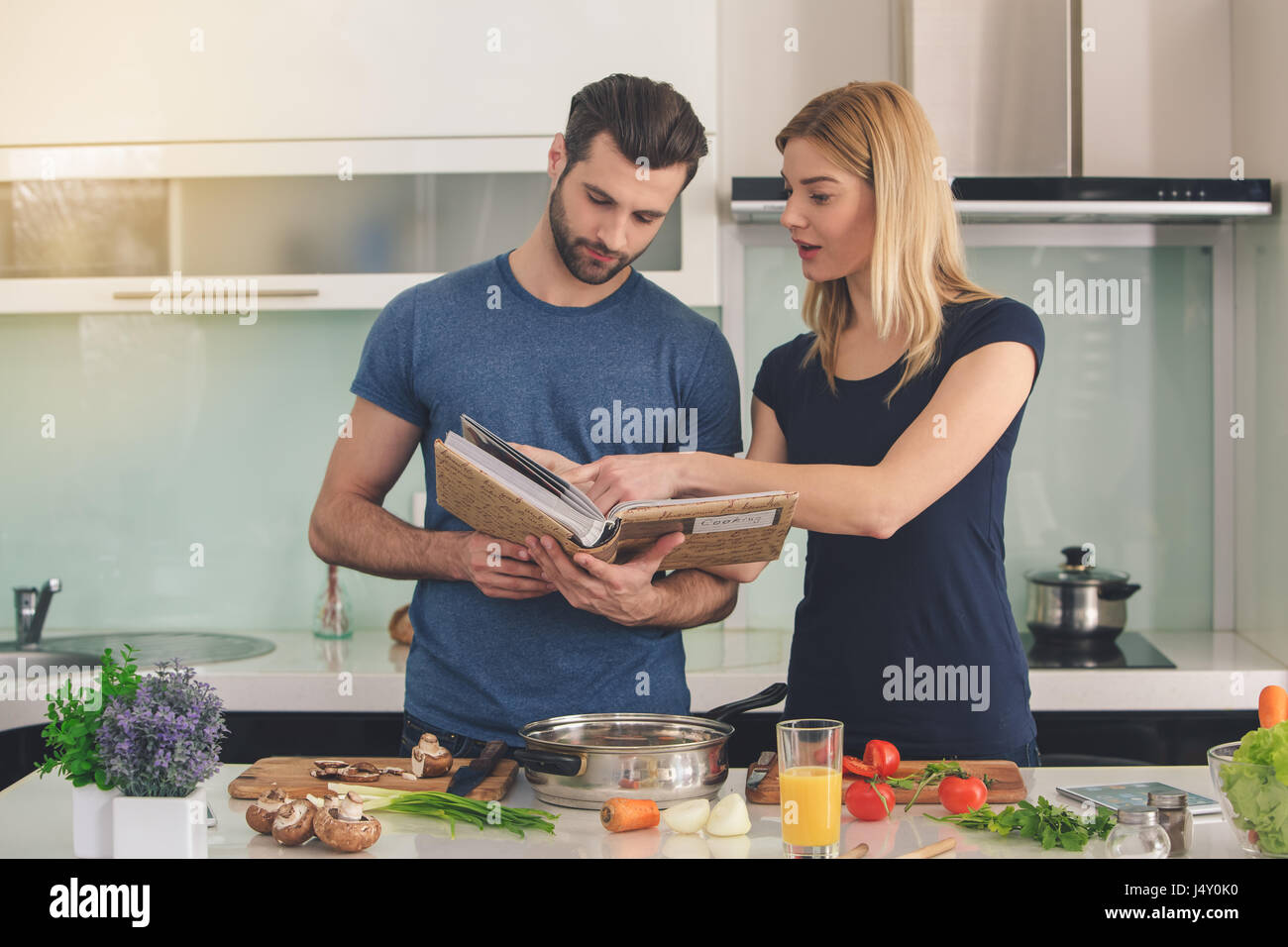 Young couple cooking together meal preparation indoor Stock Photo - Alamy
