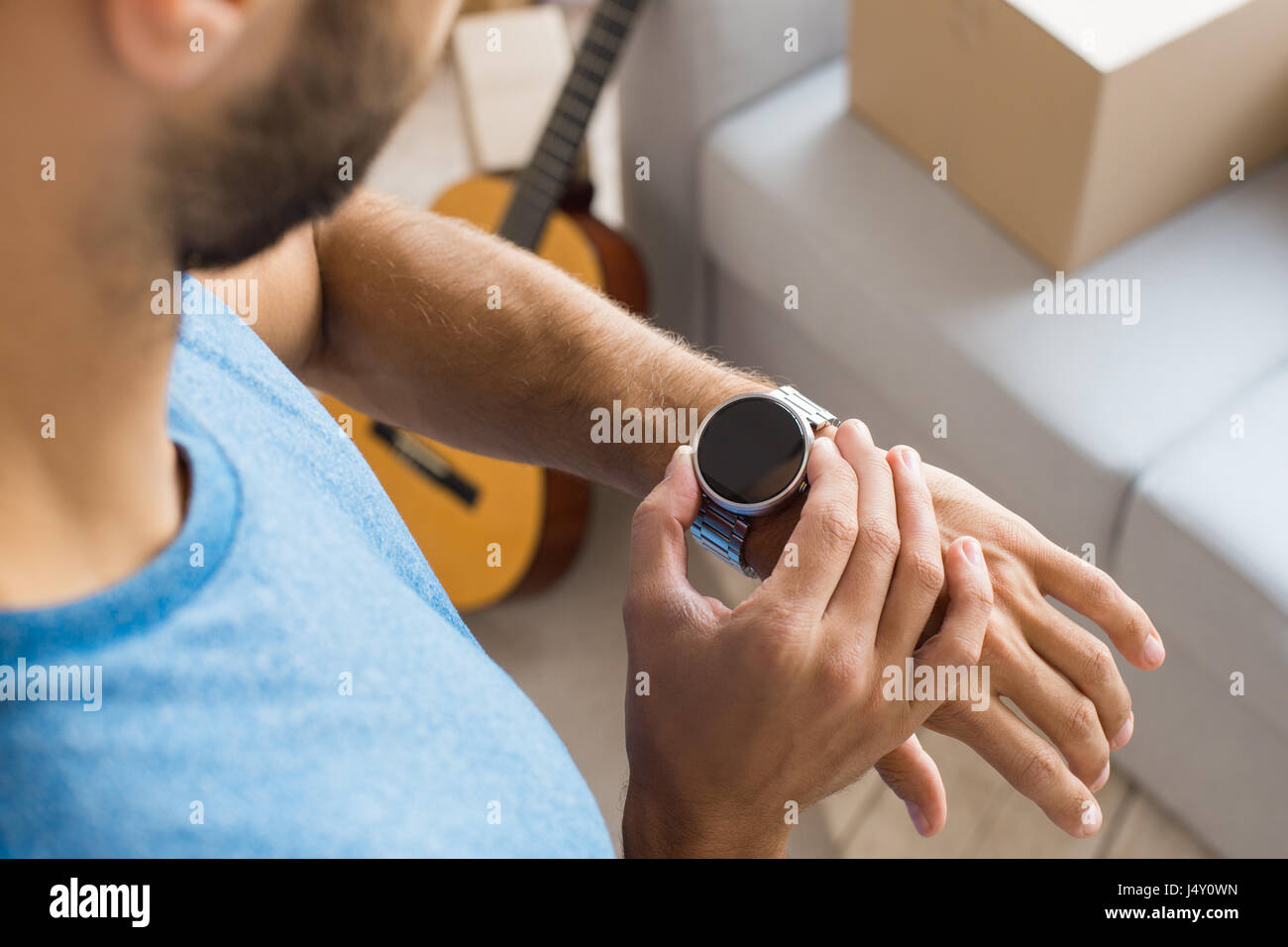 Young man checking time on watch planning relocation Stock Photo - Alamy