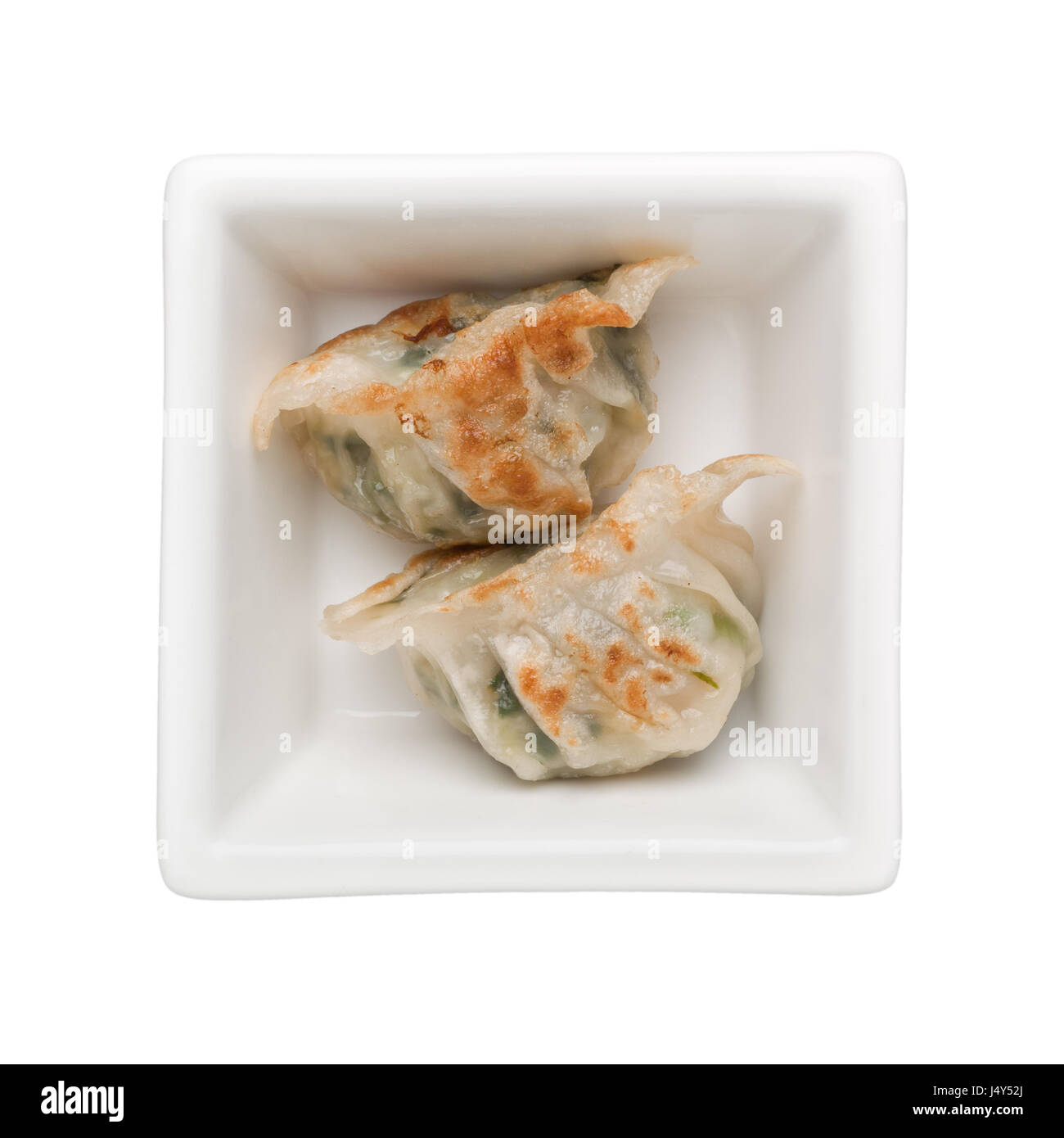 Pan-fried dumplings in a square bowl isolated on white background Stock ...