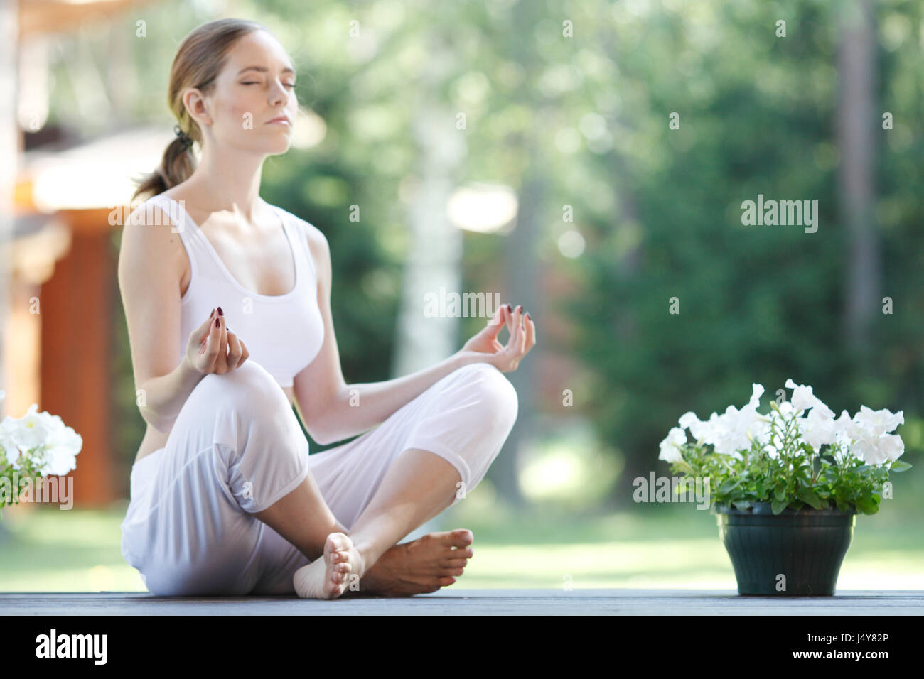 Young woman doing yoga lotus exercise outdoors Stock Photo - Alamy