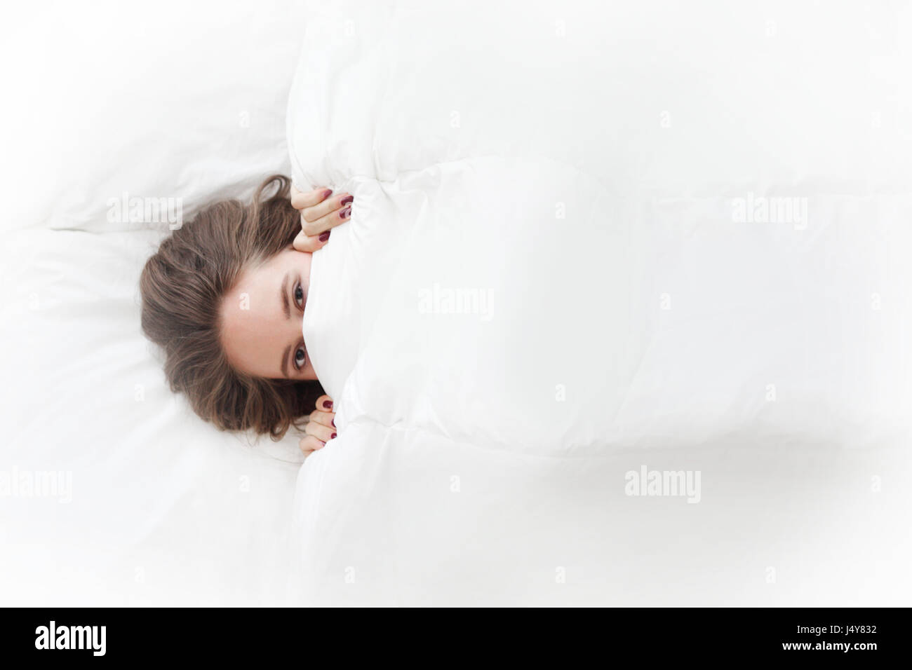 Young girl wake up in bed, top view Stock Photo - Alamy
