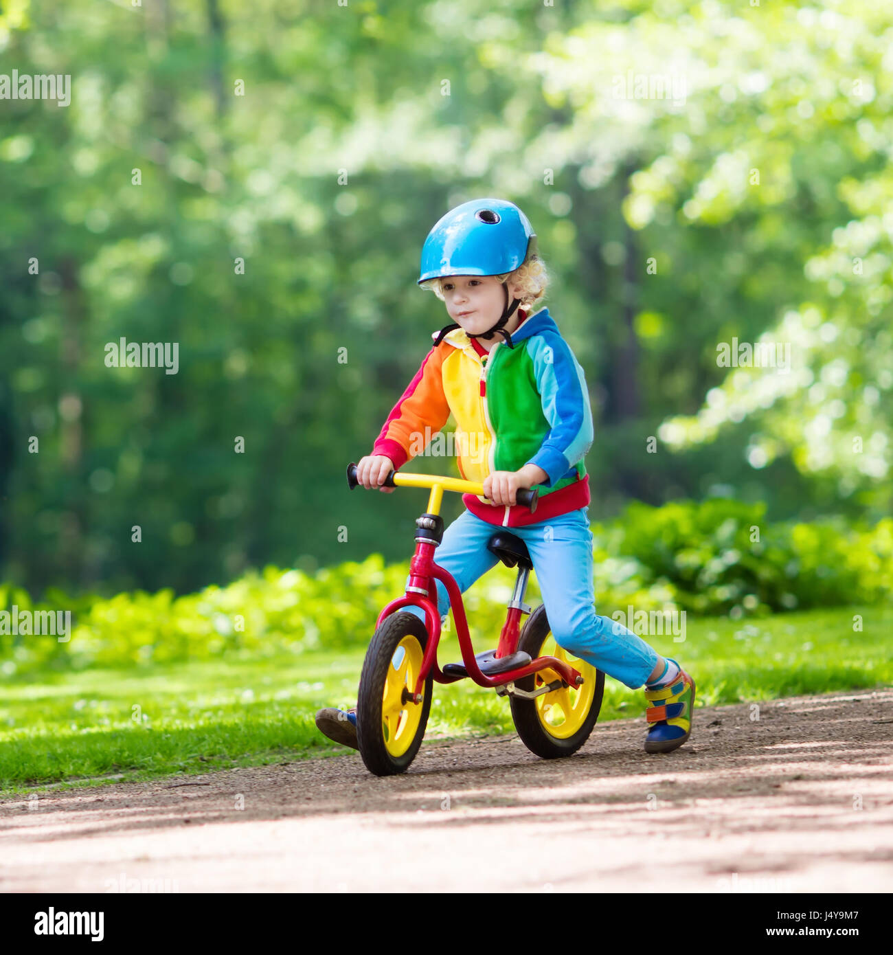 Child riding balance bike. Kids on bicycle in sunny park. Little boy ...
