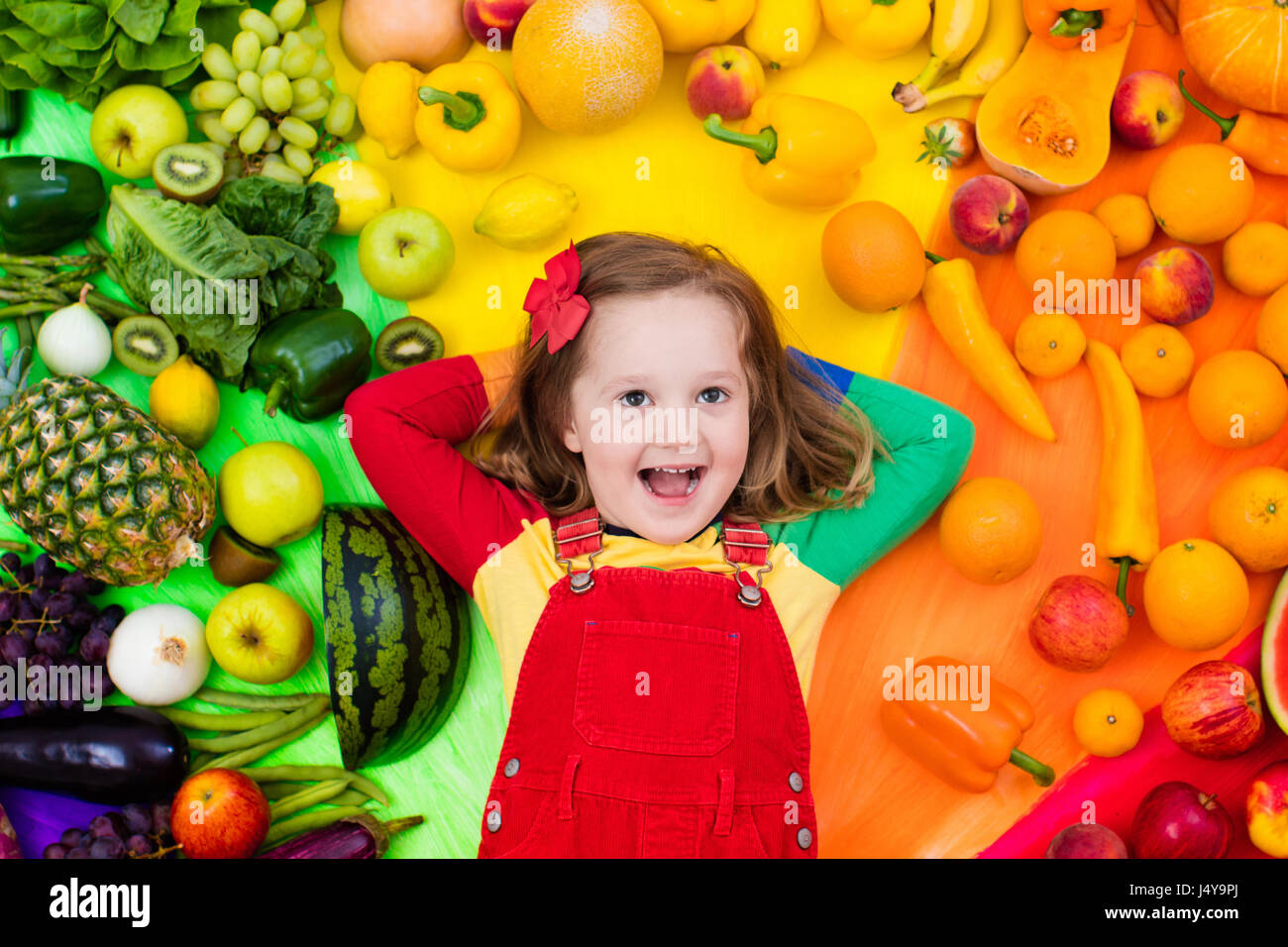 Little girl with variety of fruit and vegetable. Colorful rainbow of ...