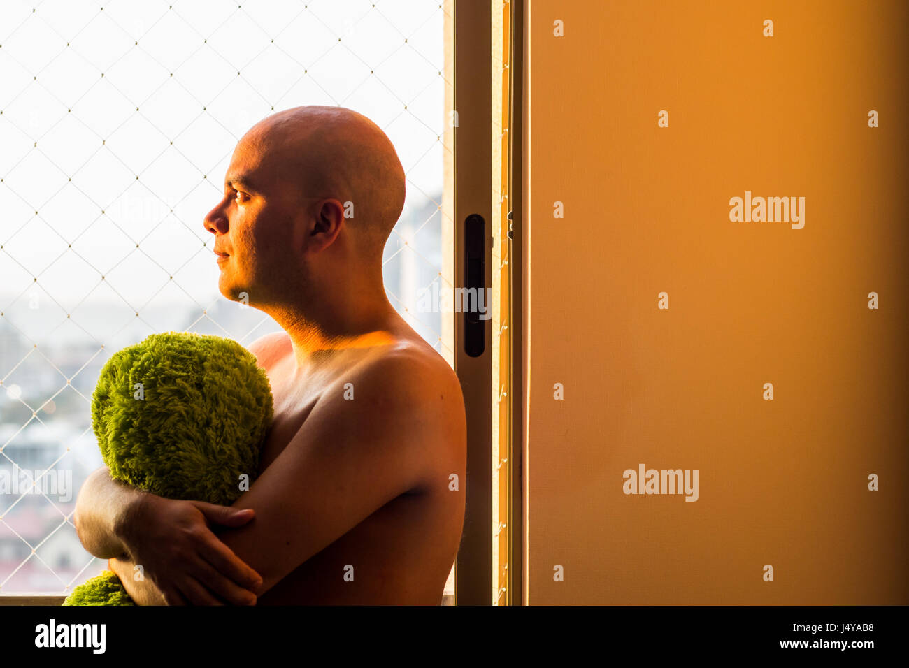 Pensive man at the window in sunset Stock Photo - Alamy