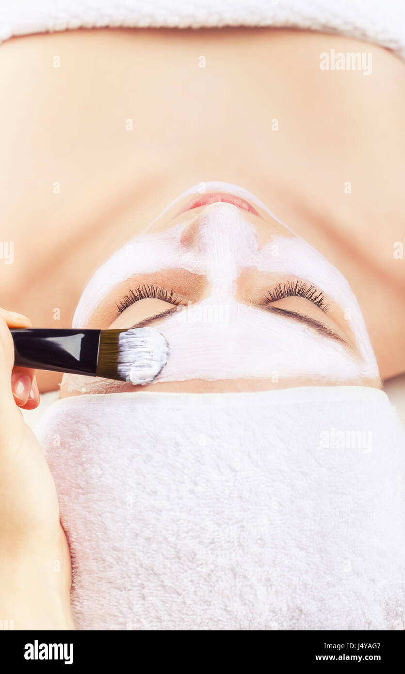 Applying facial mask at woman face at beauty salon Stock Photo - Alamy