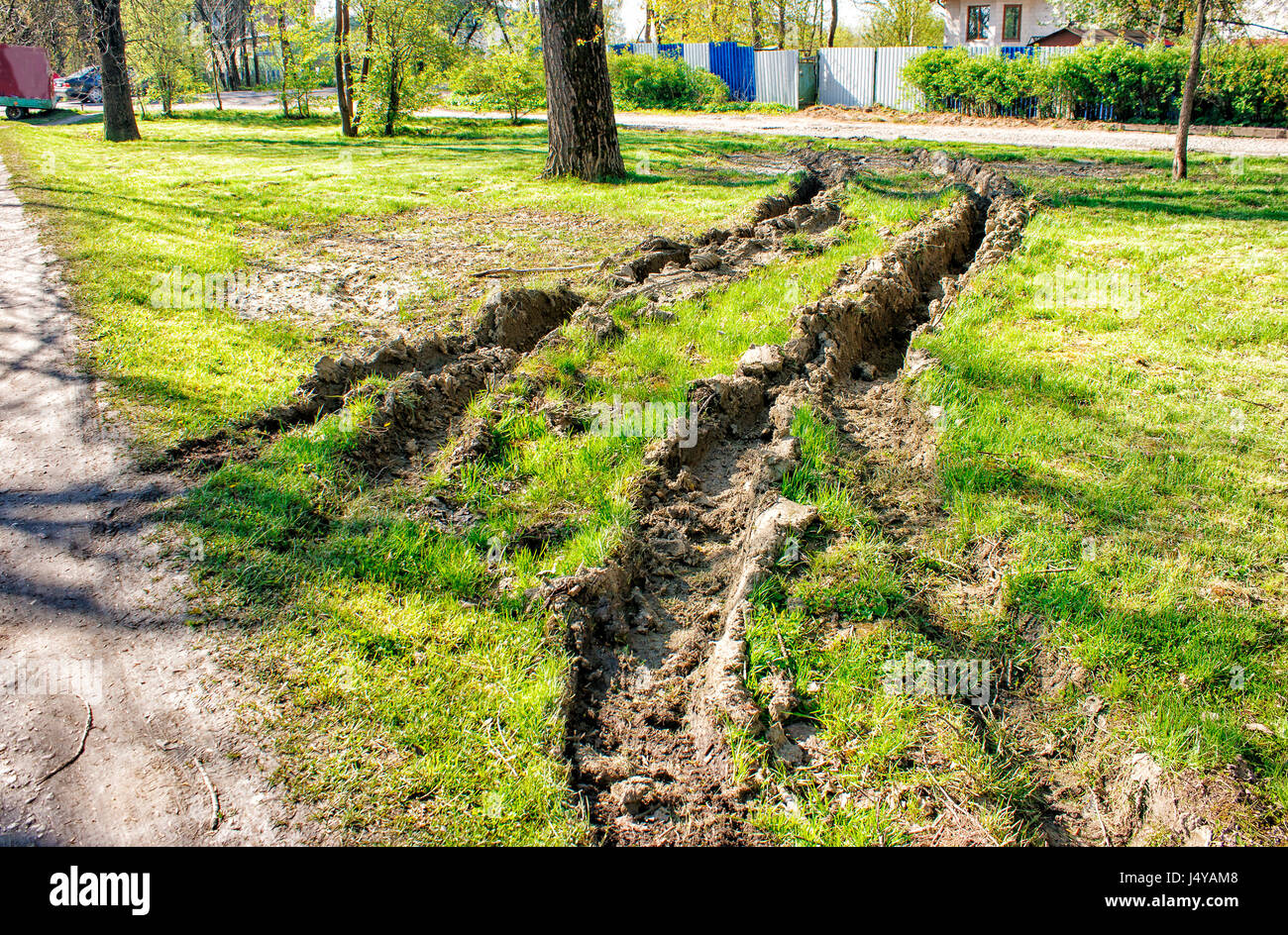 deep rut on the lawn on the city street on sunny spring day Stock Photo ...