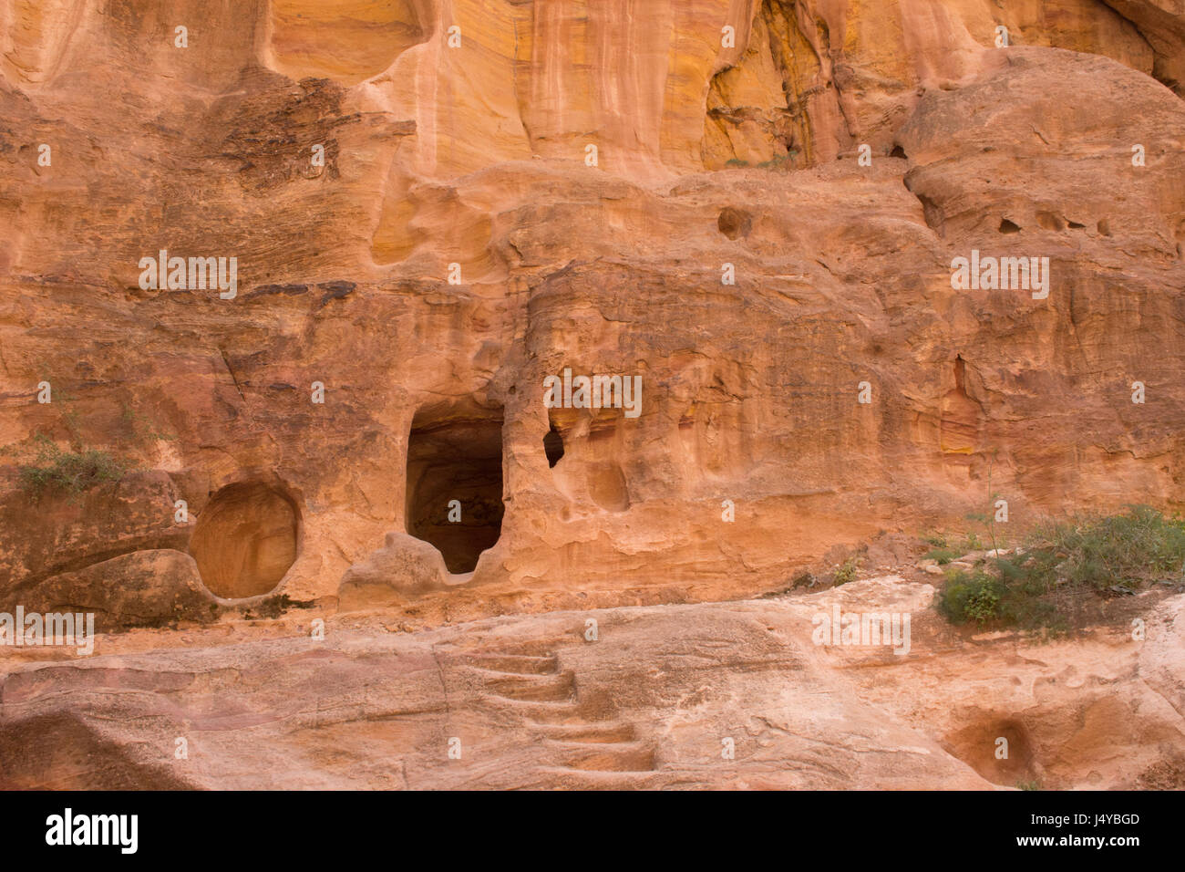 Opening in sandstone leading to cave dwelling or tomb in Petra or Raqmu ...