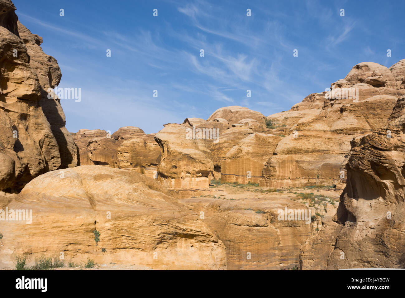 Domed, rugged sandstone formations at Petra, Jordan that are golden in ...