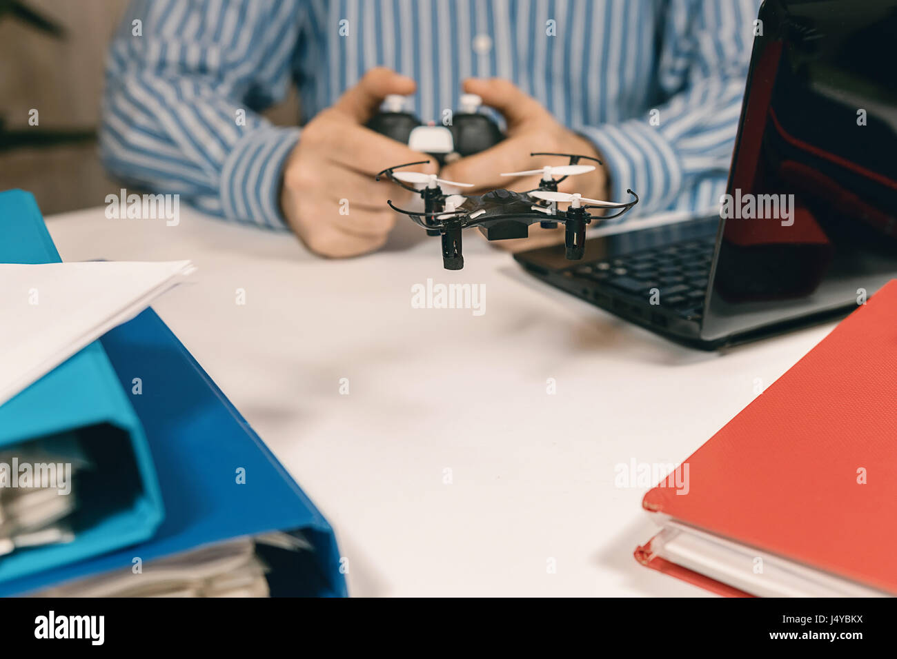 Businessman playing with drone toy at the office. Businessman testing ...