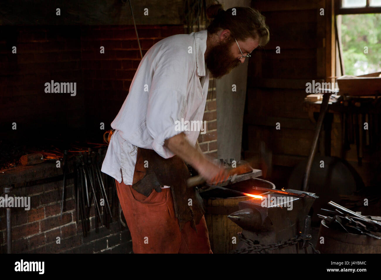 18th century blacksmith reenactor working in blacksmith shop - USA ...