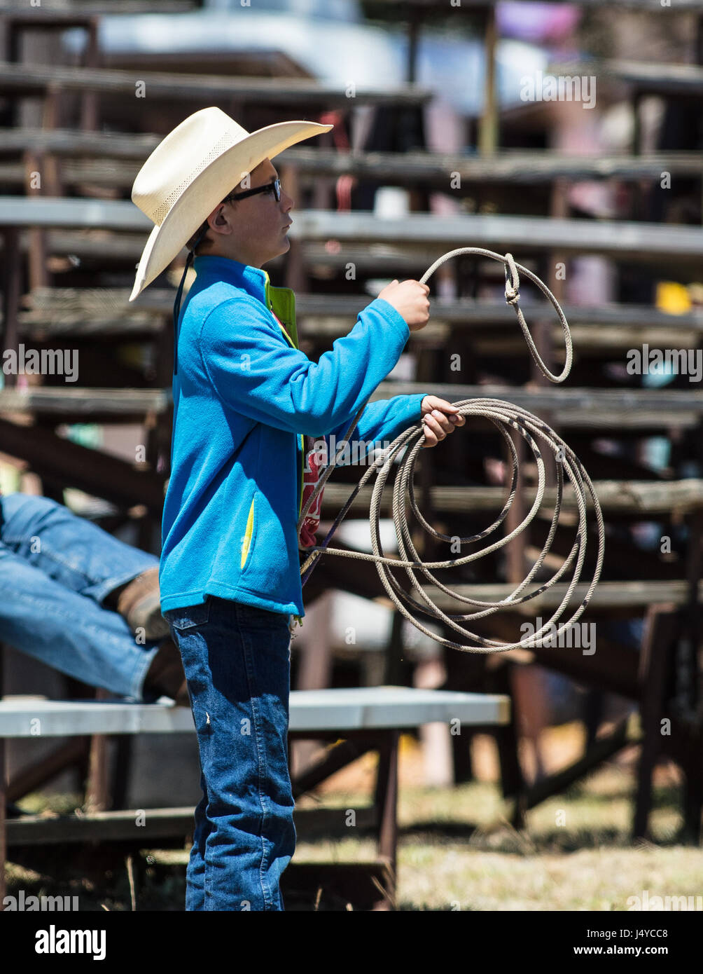 Young boy practicing rope trips while watching a rodeo in Cottonwood ...