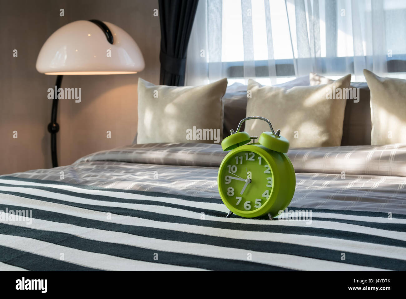 modern bedroom with green alarm clock on bed Stock Photo - Alamy
