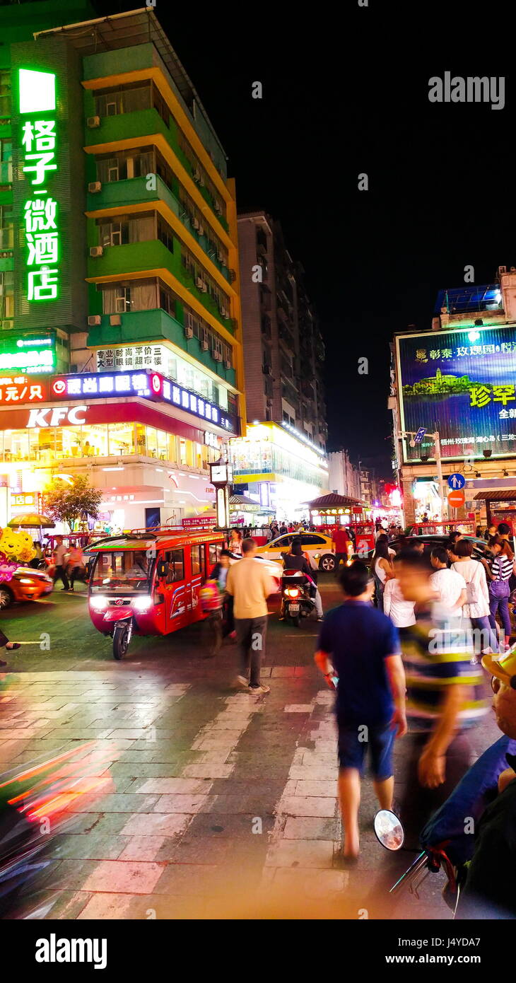 WUZHOU, CHINA - MAY 3, 2017: Old city street with people and motorbikes ...