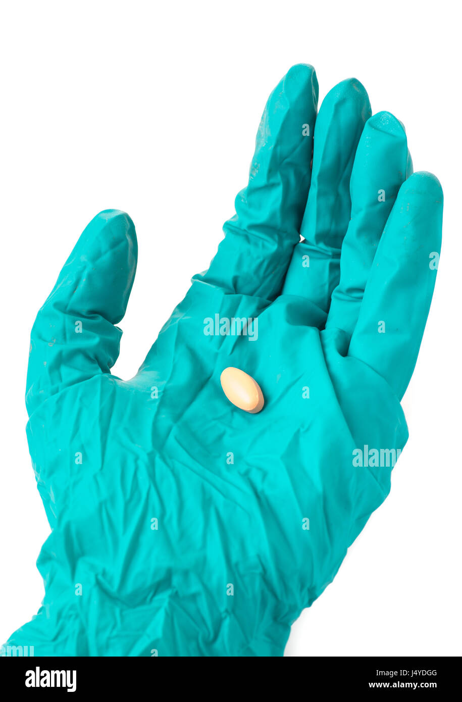 Hand with green protective glove holding an oblong pill, isolated on ...