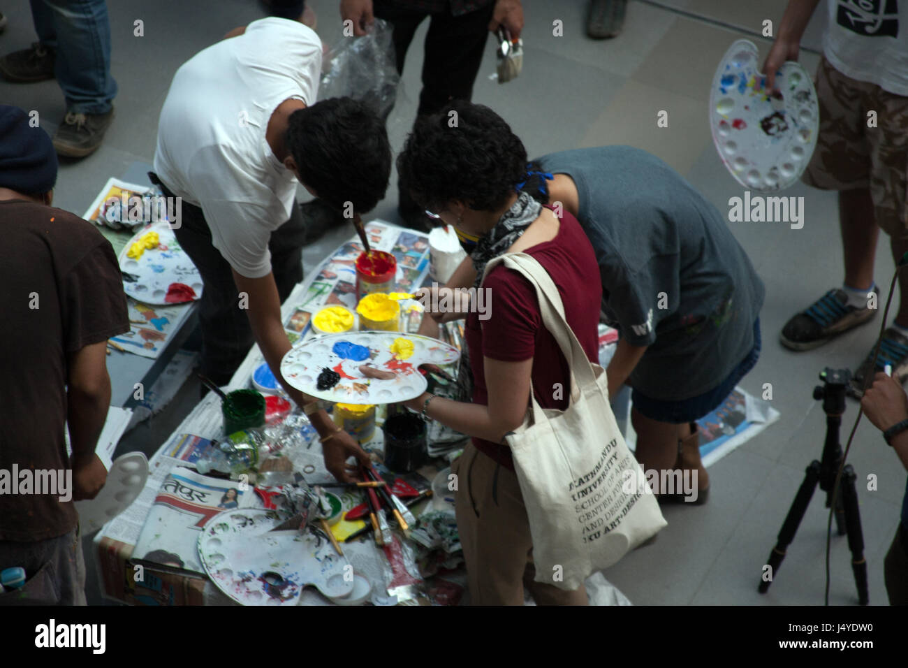 Artists putting paint on their palettes at the the Art 25 live painting ...