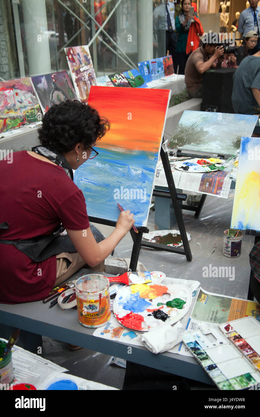 Artists painting on canvas at the Art 25 live painting competition in ...