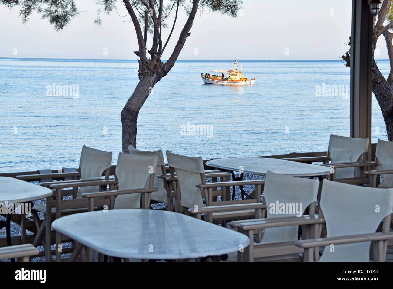 Seafront restaurant and fishing boat overlooking Kamari Beach in ...