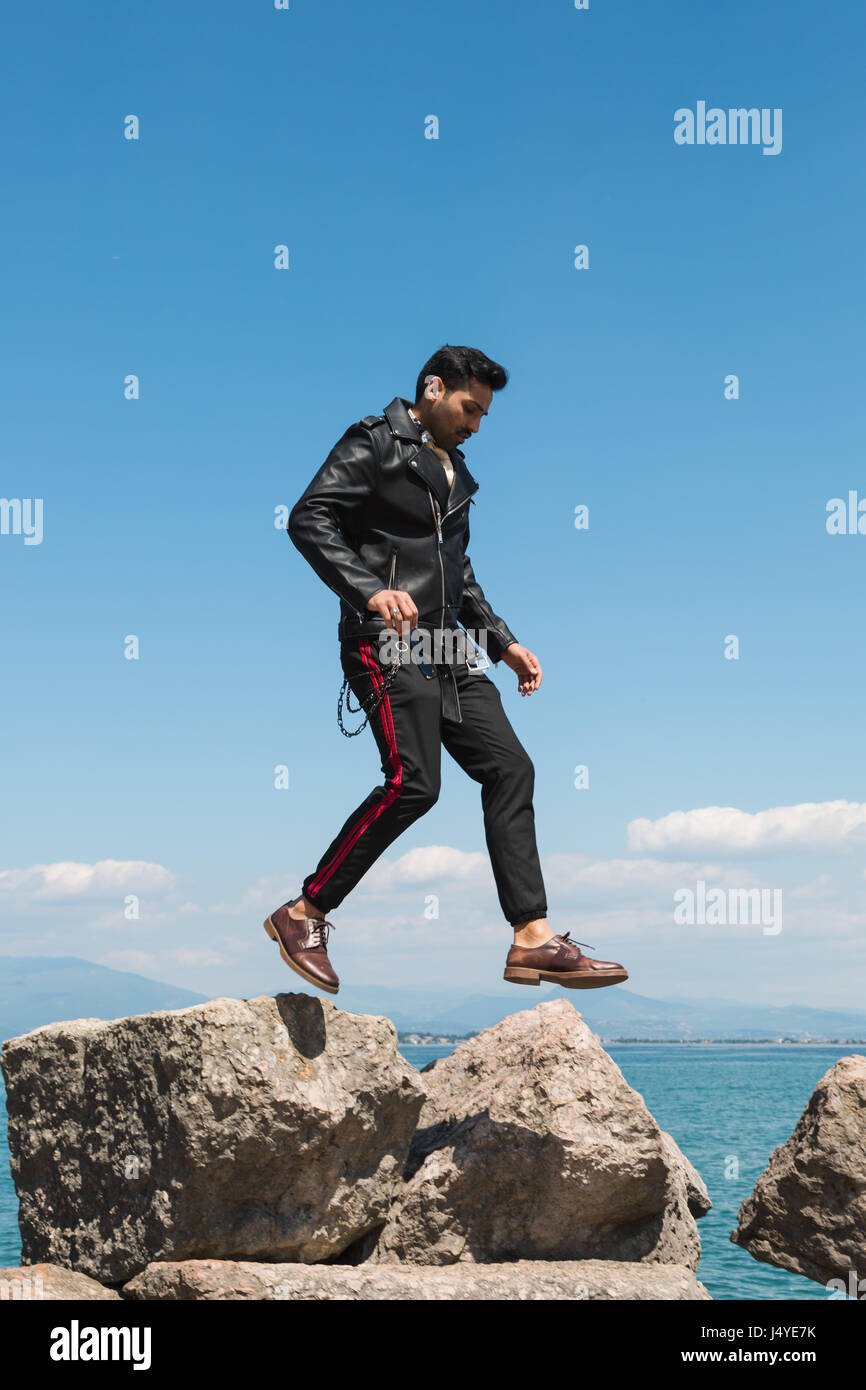 Handsome Indian man jumping in a vacation context. Street fashion and ...