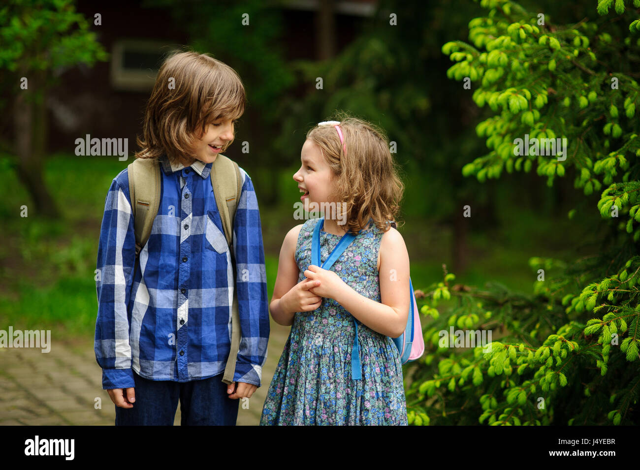 Two little school students, the boy and the girl, cheerfully ...