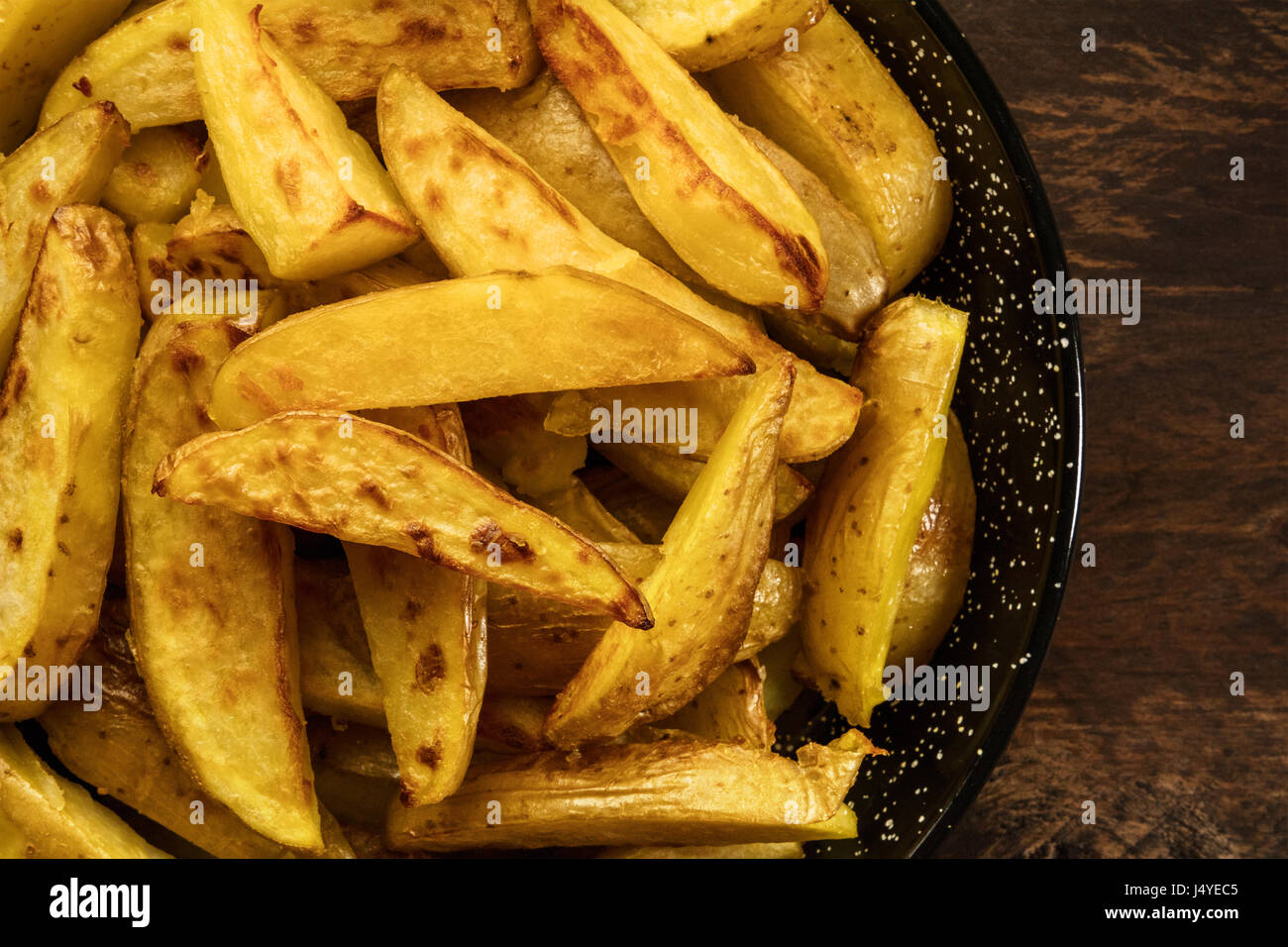 Crunchy roasted potatoes in skillet on dark rustic texture Stock Photo ...