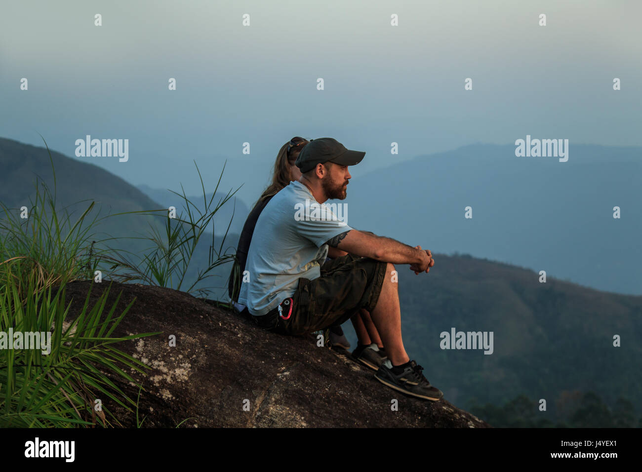 Group of tourists watching the sunset on top of the mountain. Rest ...