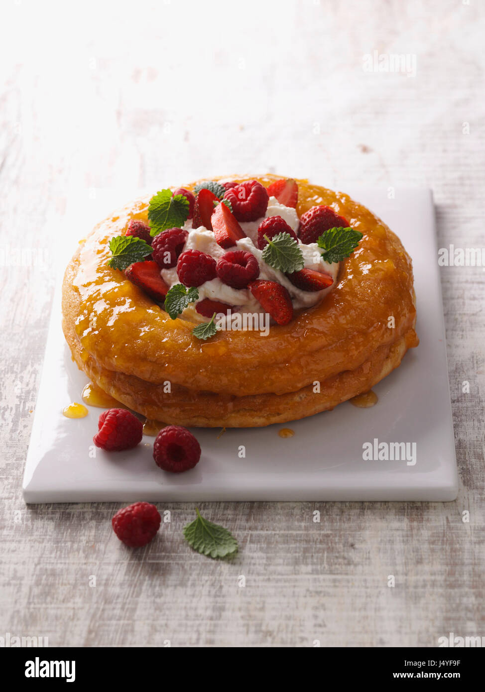 Orange savarin with berries and cream Stock Photo - Alamy