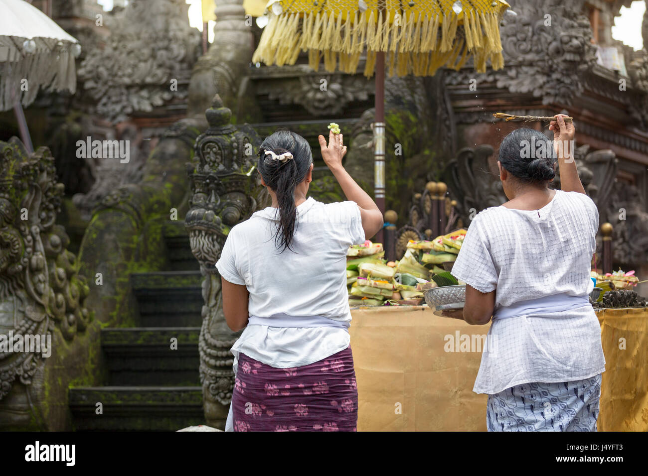 Two Asian woman praying in temple, Balinese ceremony Stock Photo - Alamy