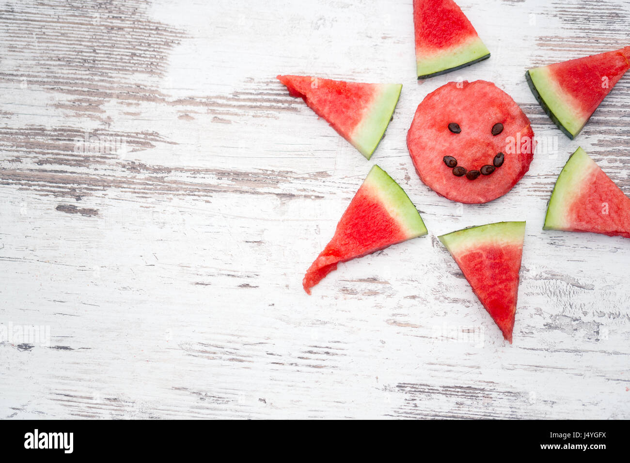 watermelon slices arranged in a corner decoration on a wooden plank ...