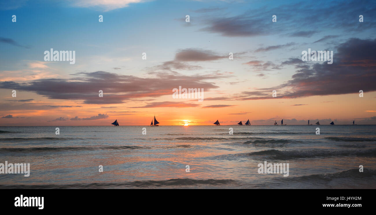 Sunset over sea, beach with colorful sky Stock Photo - Alamy