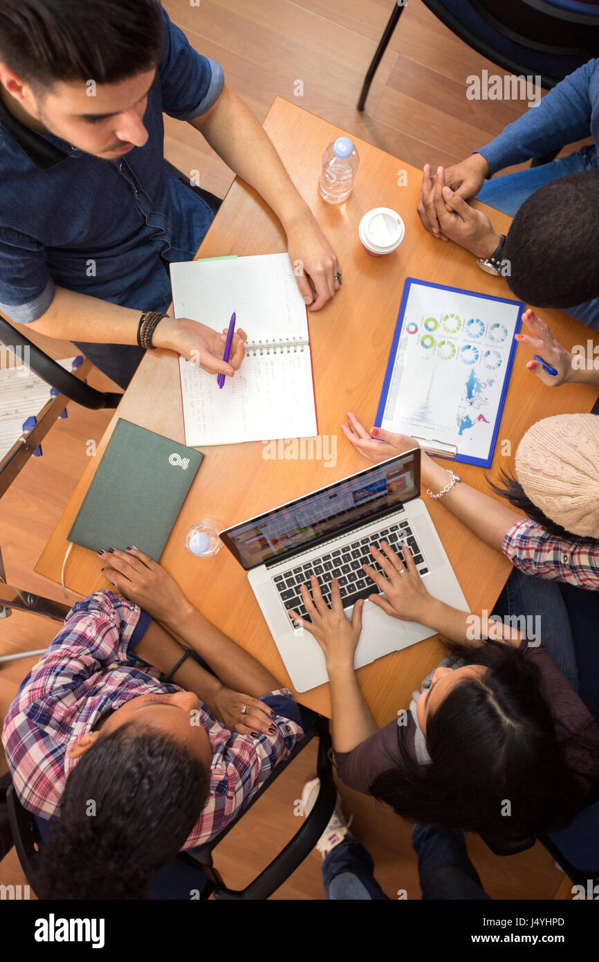 Top view of working table with students working in team Stock Photo - Alamy