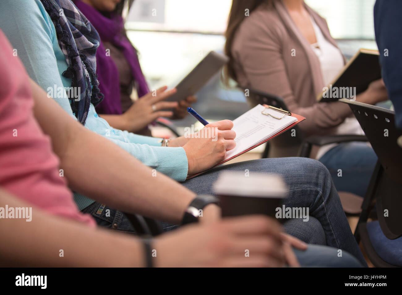 Close up view of student taking notes during lecture Stock Photo - Alamy