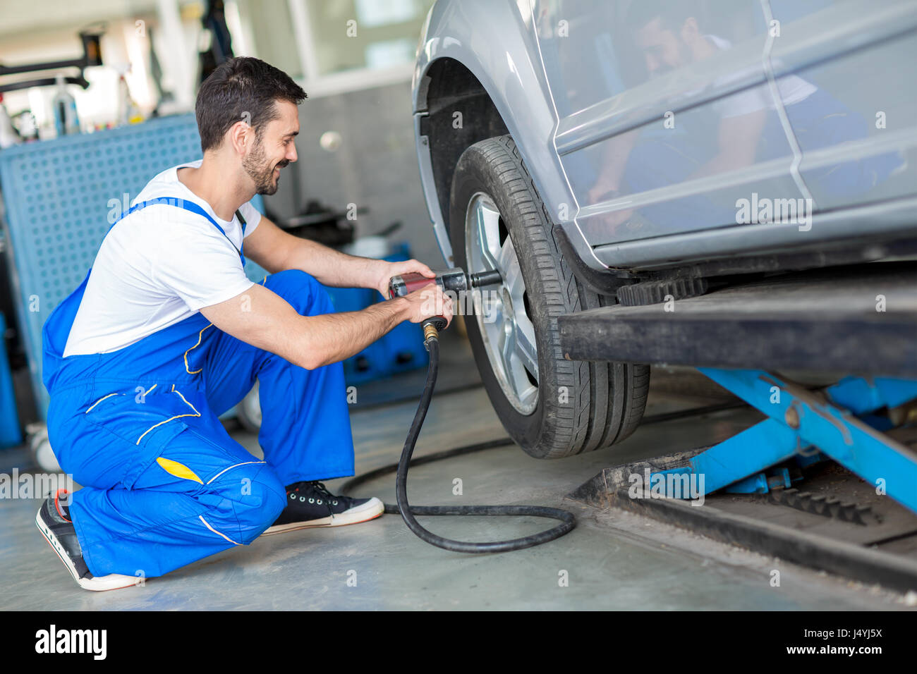 Repair mechanic working on car in garage hi-res stock photography and ...
