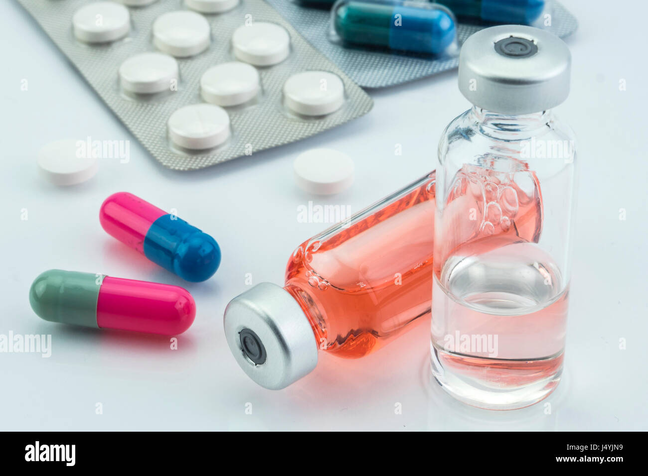 Medicine vials and pills on white background Stock Photo - Alamy