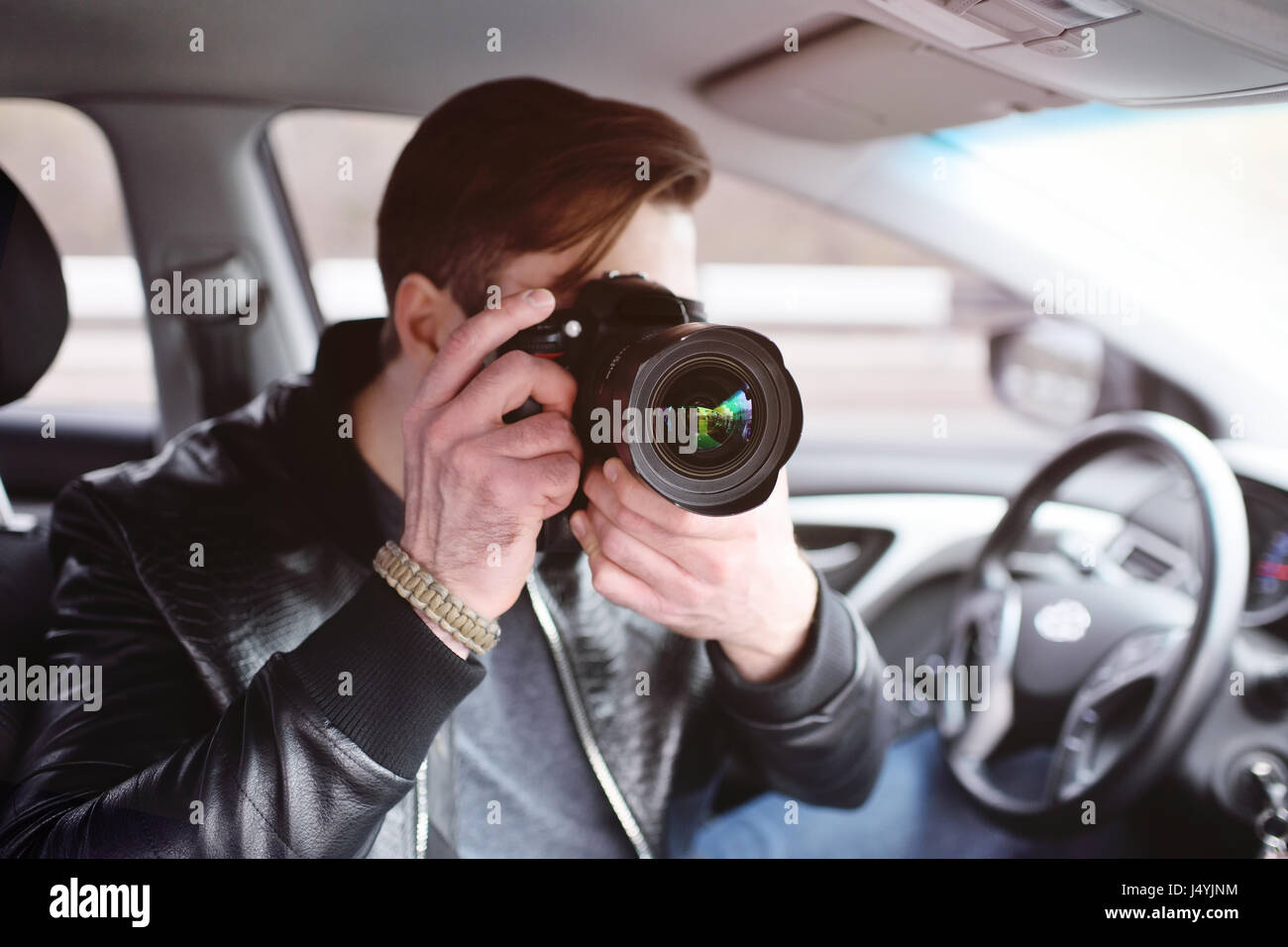 Young man with a camera in the car Stock Photo - Alamy